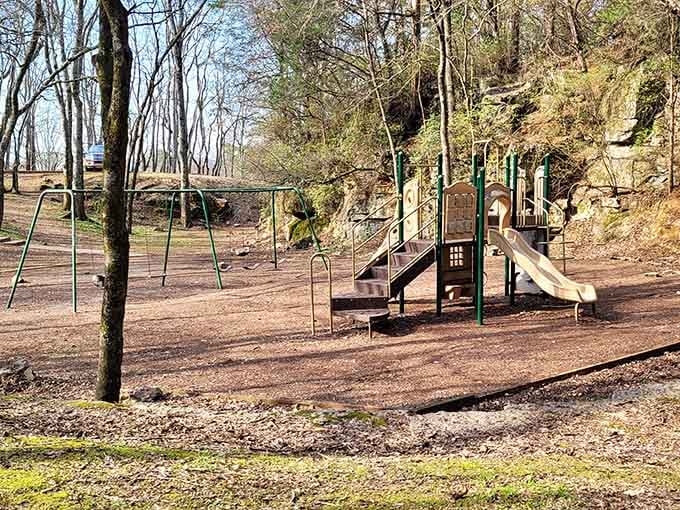Playground equipment nestles into carved limestone walls, creating a recreational space where industrial history embraces childhood fun.
