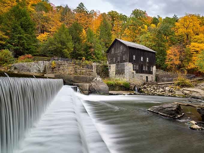 The historic mill stands proud beside rushing water, its weathered wood and stone telling stories from another century.
