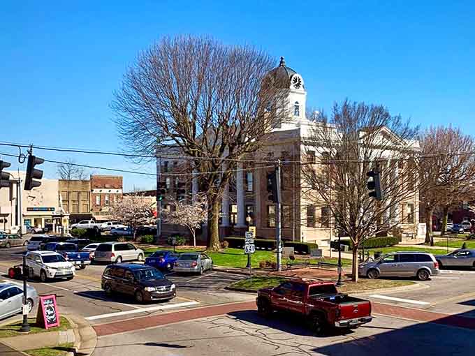 Spring blossoms frame the courthouse like nature's celebration, while the town square buzzes with small-town energy and pride.