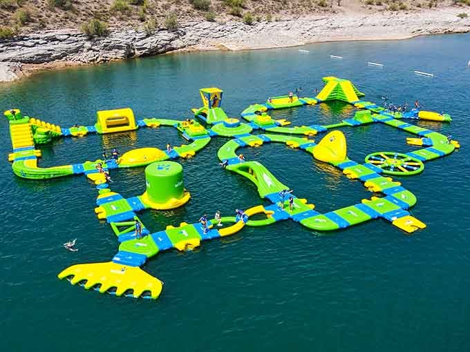 This floating obstacle course looks like Willy Wonka designed a water park on the lake.