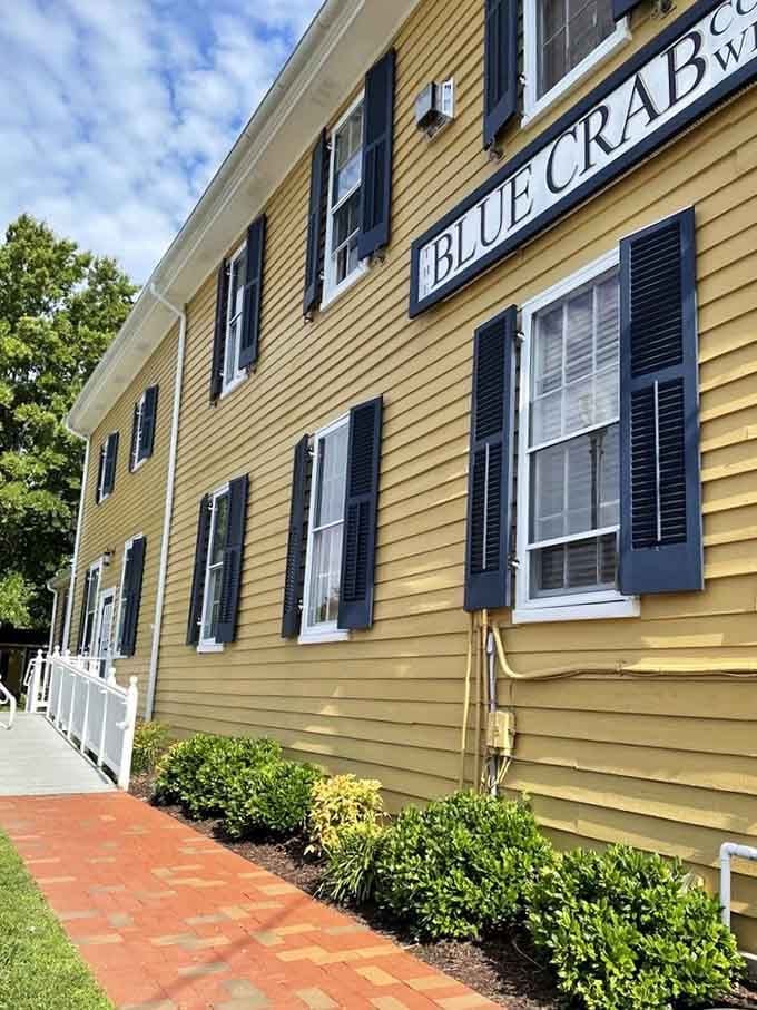 Classic yellow clapboard with black shutters creates a timeless New England vibe perfect for morning coffee rituals.