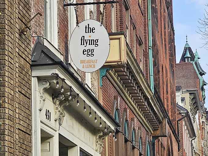 That vintage blade sign jutting from historic brick makes finding breakfast feel like discovering a downtown treasure hunt prize.