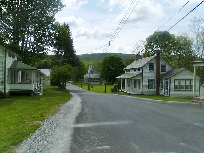 Mountains rise behind simple white houses in this peaceful hamlet where nature sets the pace.