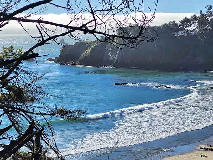 Morning mist adds mystery to this secluded beach where waves whisper secrets to the rocky shore.