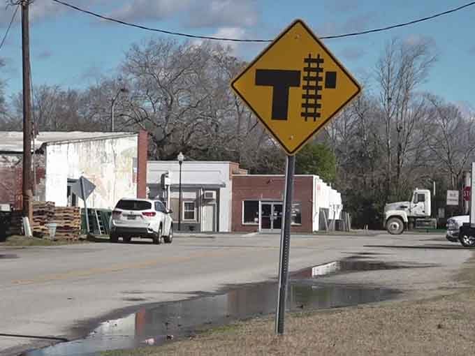 That railroad crossing sign stands as a reminder of when these small towns were vital stops on important journeys.