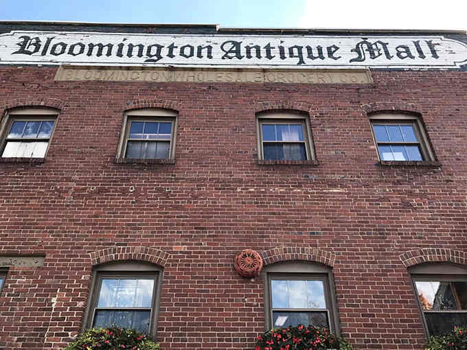 That fancy Gothic lettering across red brick looks like something from a Victorian-era advertisement come alive.