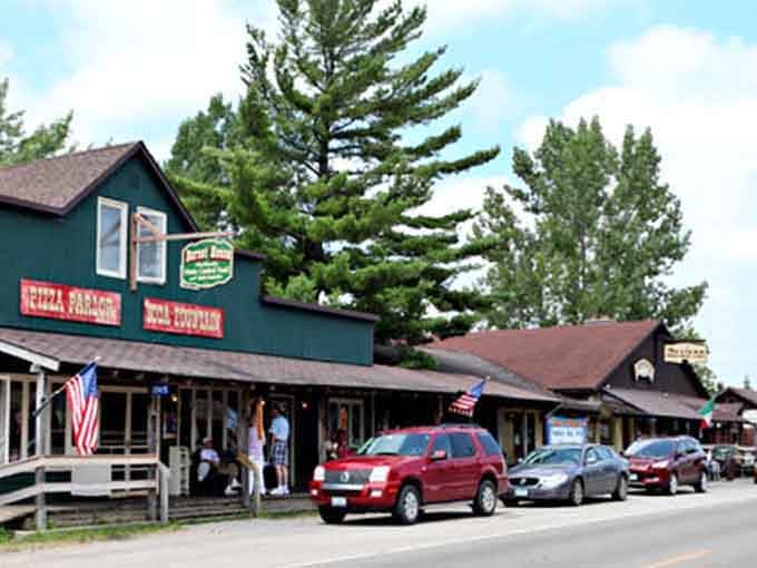 Local shops line up under towering pines, creating that north woods vibe where flannel shirts are always considered formal wear.