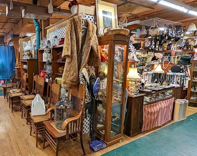 Vintage clothing hangs like colorful memories while jewelry sparkles on tables in this charming indoor marketplace.