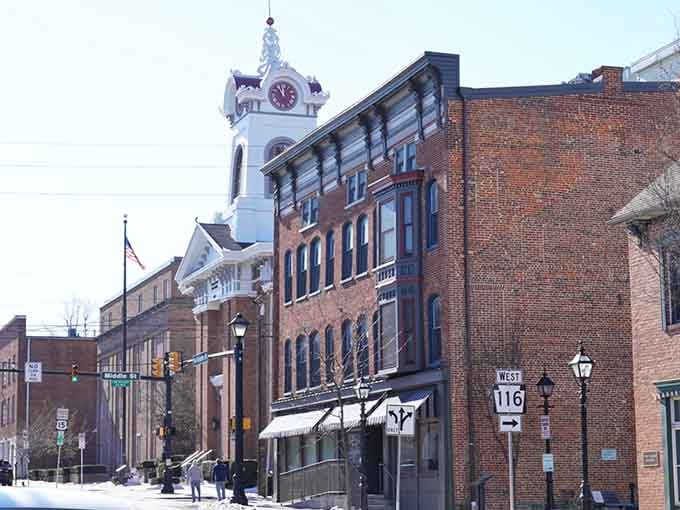 The elegant clock tower rises above historic buildings like a beacon, reminding everyone that some towns never forgot how to be beautiful.