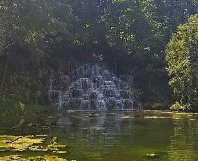 Morning mist rises from the tranquil pool as sunlight catches each tier of this gentle, mesmerizing cascade.