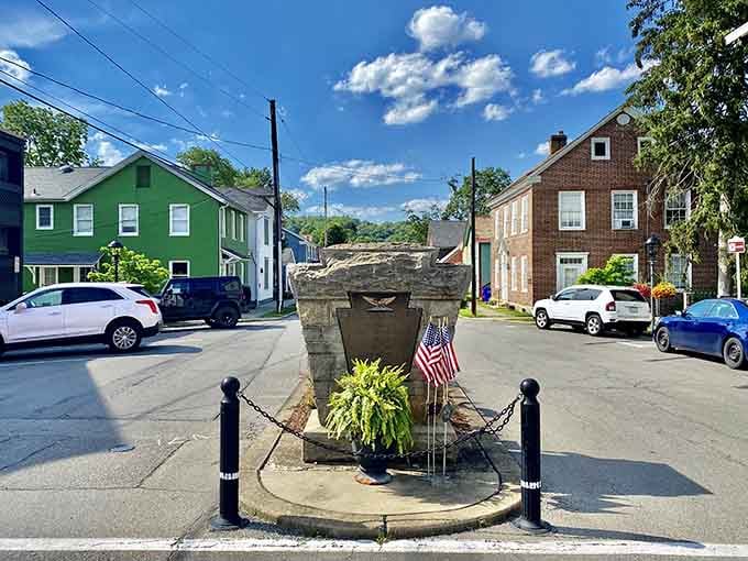 A stone monument stands proudly at the intersection, decorated with flowers and patriotic displays year-round.