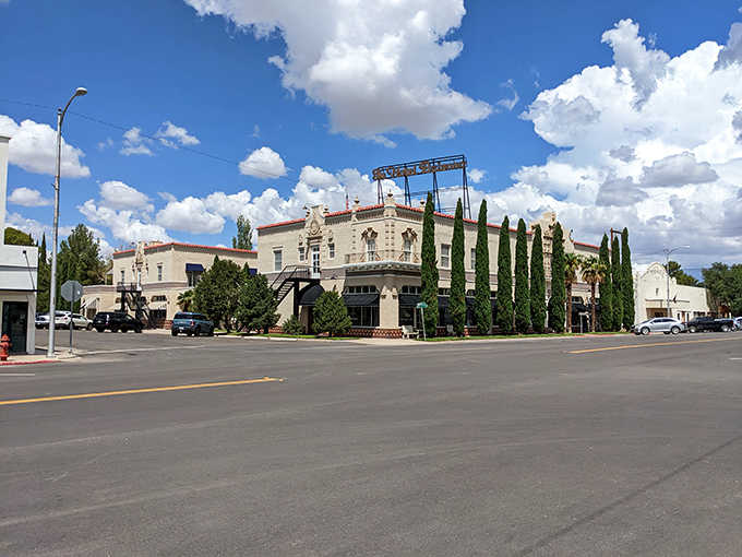 Tall cypress trees frame Spanish-style architecture that looks transplanted from a Mediterranean village, minus the ocean breeze.