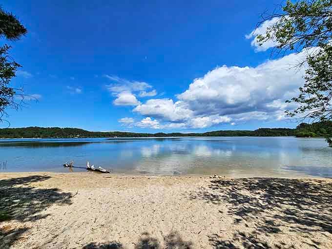 Crystal-clear pond water reflects puffy clouds in a scene so perfect it looks like someone painted it.
