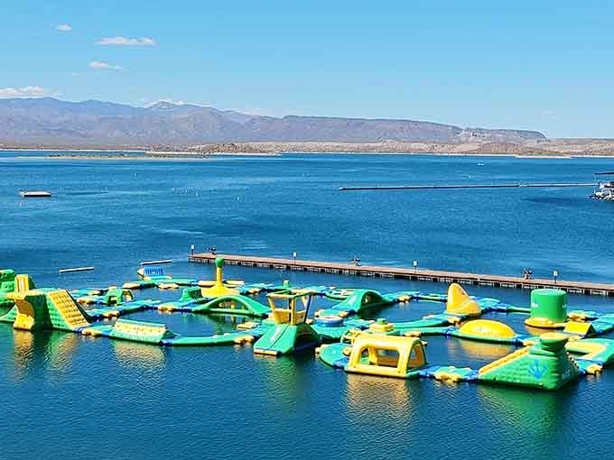 The sprawling inflatable playground stretches across pristine blue water with mountain views that steal the show.