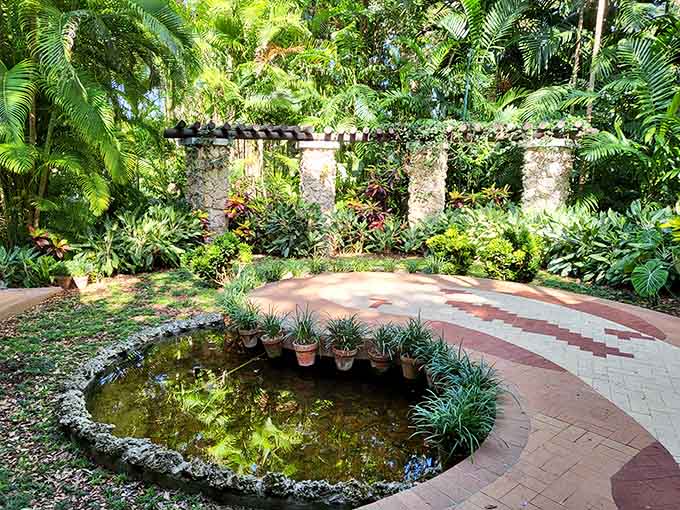 Weathered columns frame a secret garden path where ferns and flowers create their own tropical symphony.