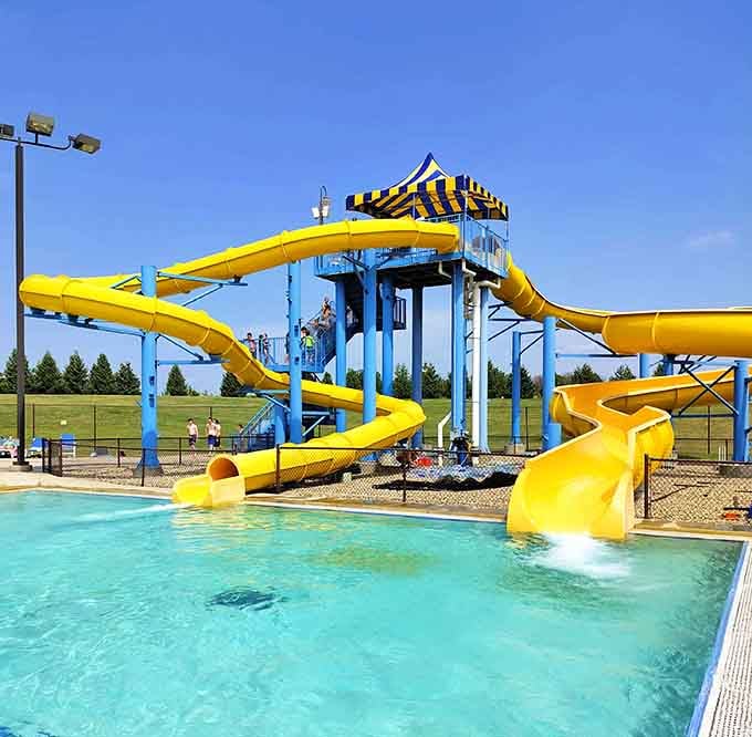 Bold yellow slides curving sharply against a cloudless blue sky at River Springs prove that southern Minnesota knows exactly how summer should feel.