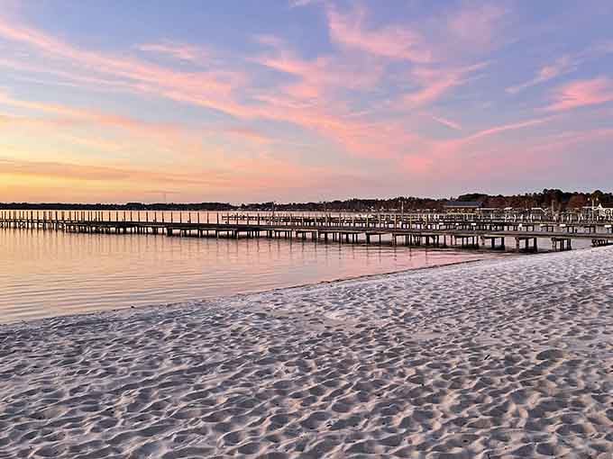 Cotton candy skies at sunset paint the lake and sandy beach in soft shades of pink and lavender.