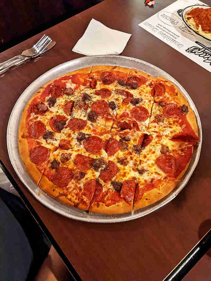 That golden crust and generous pepperoni coverage represent nearly ninety years of pizza-making wisdom on a single pan.