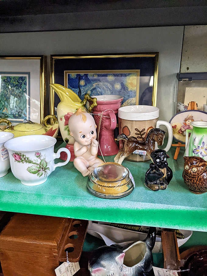 Kewpie dolls and vintage ceramics mingle with art prints, creating delightful chaos only antique lovers truly understand.