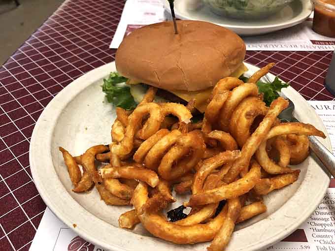 A cheeseburger paired with curly fries that could make a vegetarian reconsider their life choices, temporarily.