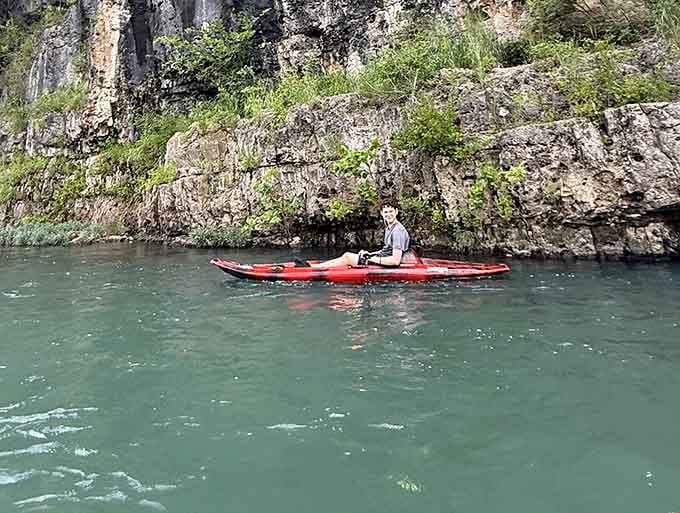 Paddling these impossibly clear waters feels like floating through liquid emerald under towering bluffs.