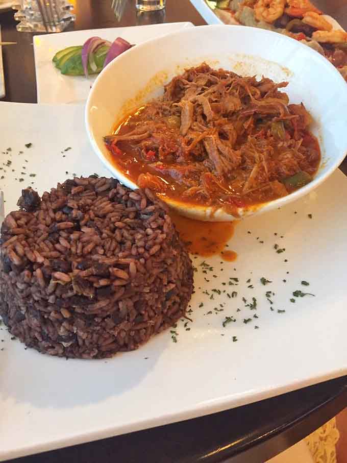 Ropa vieja's tender shredded beef nestled beside perfectly molded black rice creates comfort food poetry on a plate.