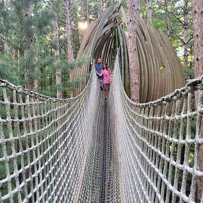 A rope bridge leads to a wooden pod structure that looks straight out of a fantasy adventure novel.