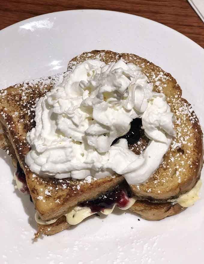 French toast dusted with powdered sugar and crowned with whipped cream, because subtlety is overrated before noon.