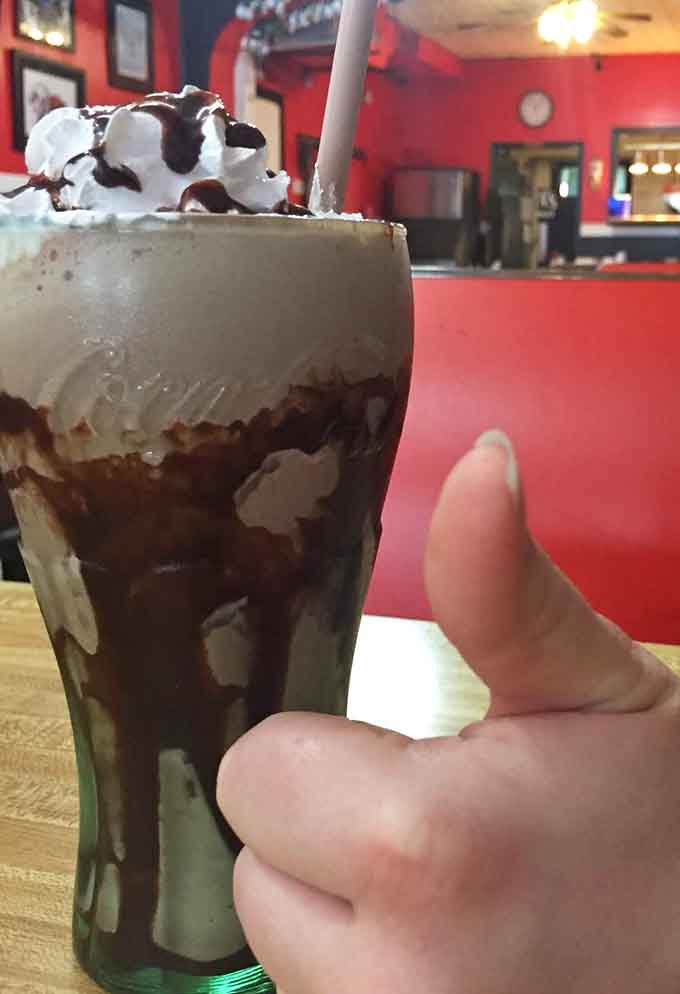 The chocolate shake arrives looking like it could anchor a ship, thick enough to stand a spoon upright.