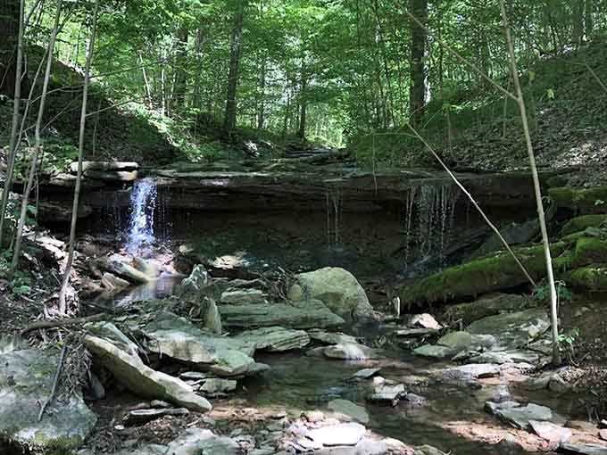 A hidden waterfall adds unexpected natural beauty to your historical hiking adventure through the woods.