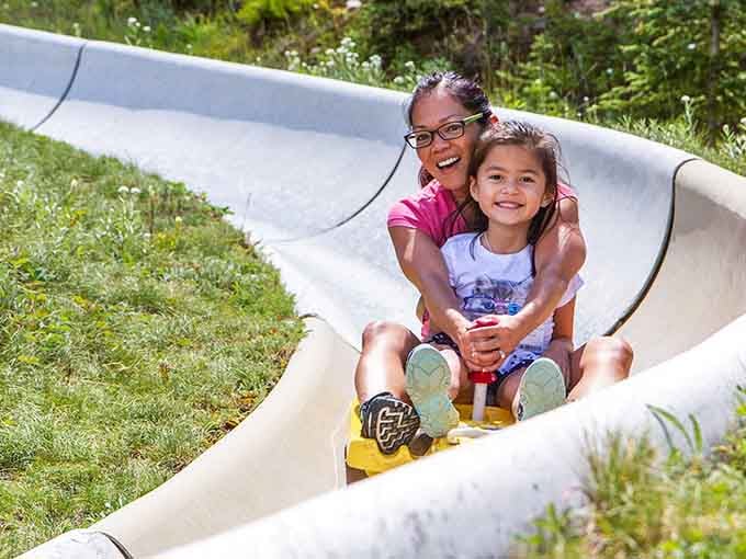 Pure joy captured mid-slide, the kind of happiness that makes your cheeks hurt from smiling too much.