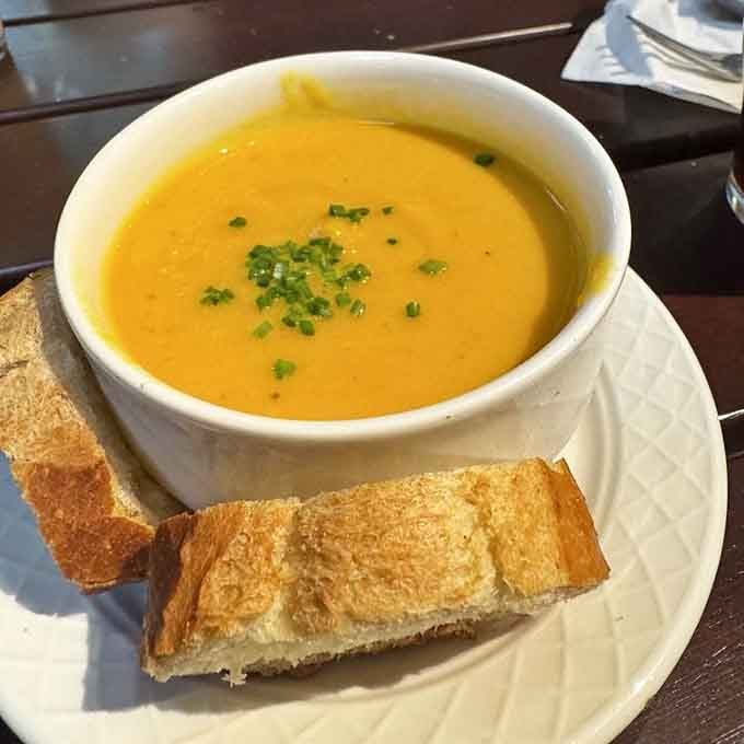 Golden soup with fresh bread is comfort food that actually earns the title instead of just claiming it.