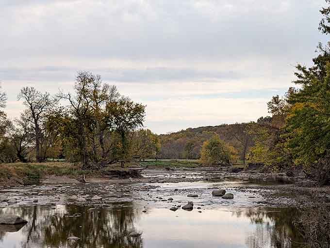 The Des Moines River at low water reveals smooth stones and peaceful reflections worth contemplating.