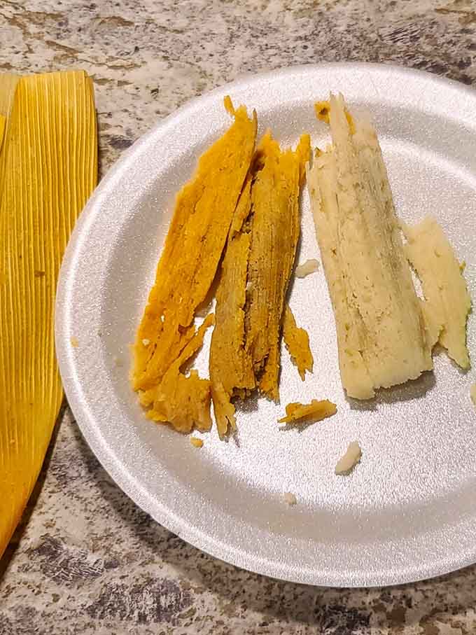 Two tamales, side by side, showing off their golden masa like they know they're the stars.