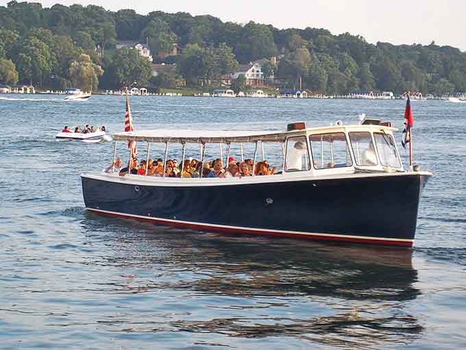 A sleek tour boat carries happy passengers across the sparkling lake, creating memories one wave at a time.