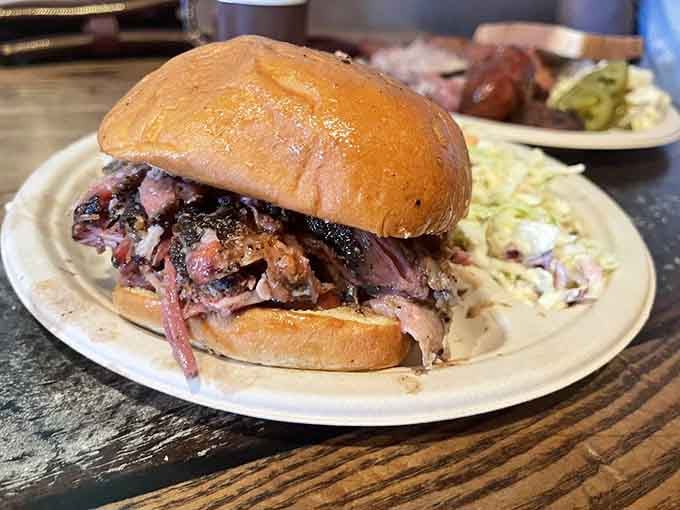 This pulled pork sandwich towers with smoky goodness, challenging both your jaw capacity and your willpower simultaneously.