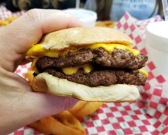 Two patties, multiple cheese layers, pure architectural genius between two buns that barely contain the glory.