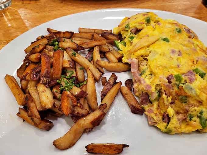 Those signature roasted potatoes deserve their own fan club, paired here with a loaded omelet masterpiece.