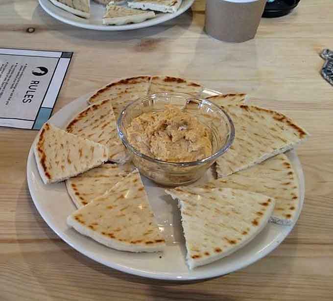 Warm pita triangles surrounding creamy hummus, the kind of simple pleasure that makes you wonder why you ever complicated lunch.