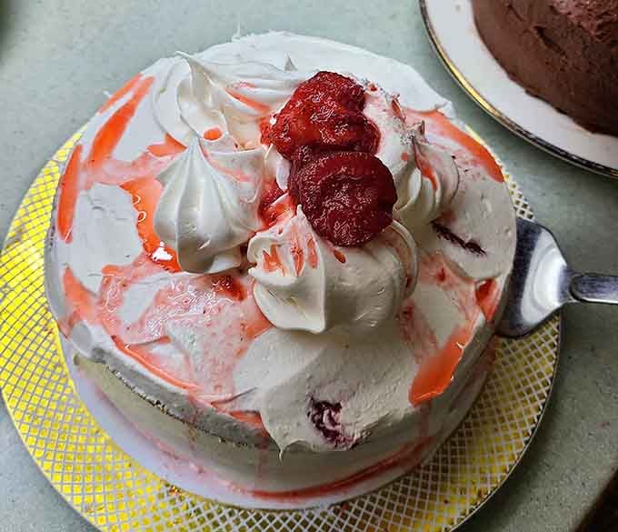 Strawberry cake with whipped cream rosettes so pretty you'll almost feel guilty eating it. Almost.