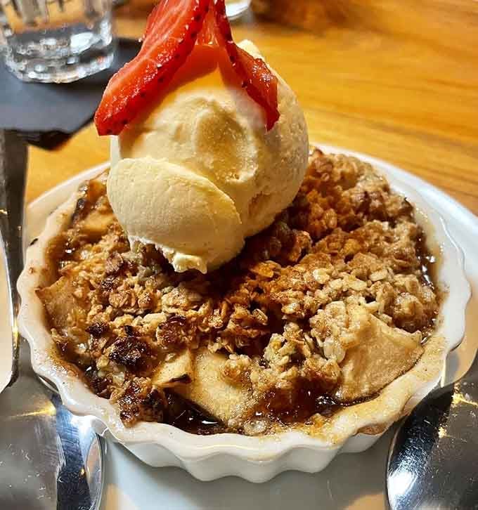 Apple crisp topped with ice cream and strawberries, because sometimes dessert needs to make a bold statement.