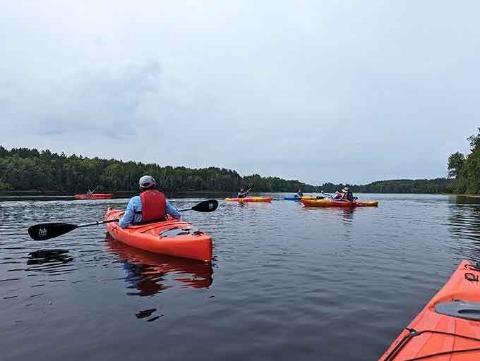 Bright kayaks gliding across glassy water, proving the best therapy doesn't require a couch or copay.