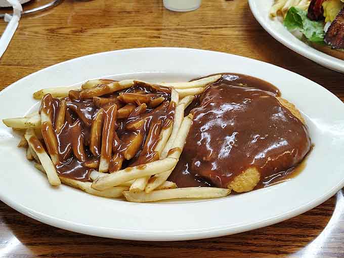 Chicken fried steak and fries covered in brown gravy, because subtlety is overrated at breakfast time.