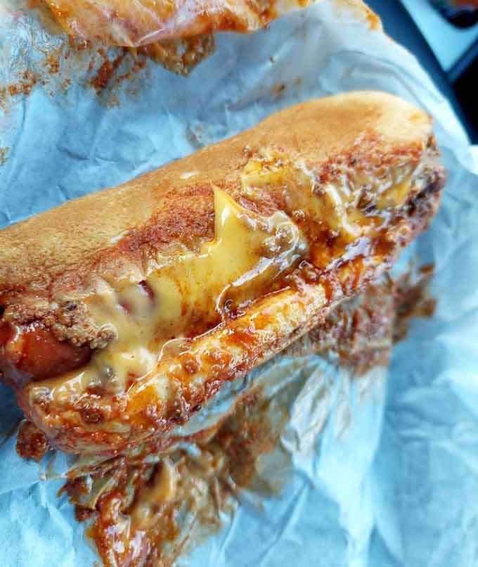 Look at that glorious cheese pull stretching from bun to filling, proving physics can be absolutely delicious.