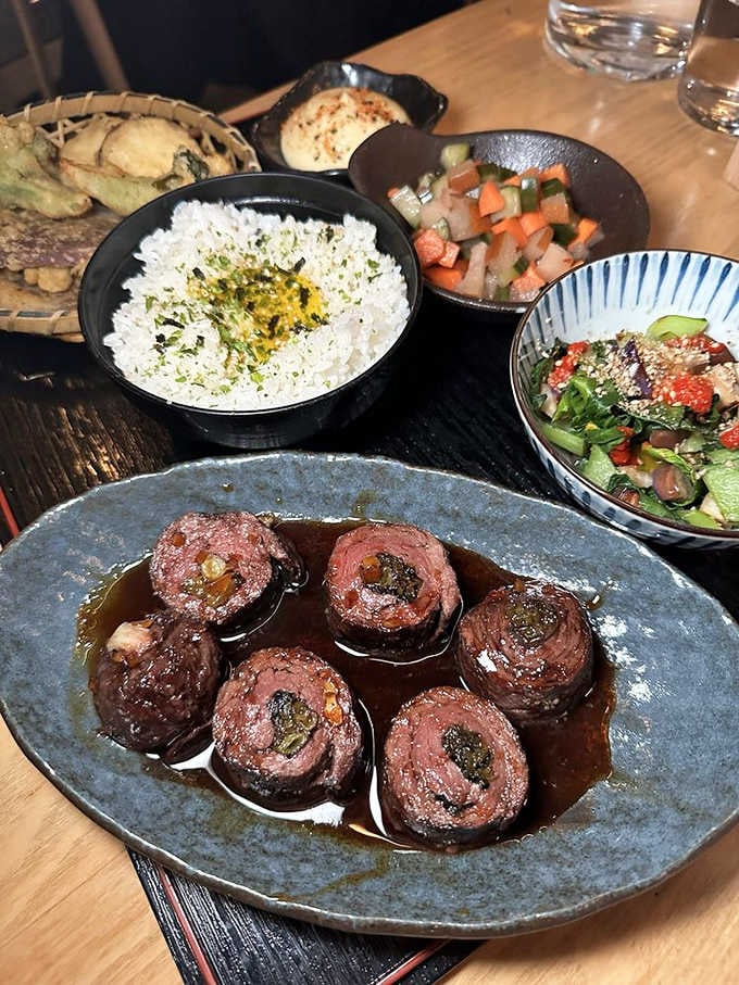 This beautifully composed spread showcases Japanese comfort food at its finest, from rice to perfectly seared beef rolls.