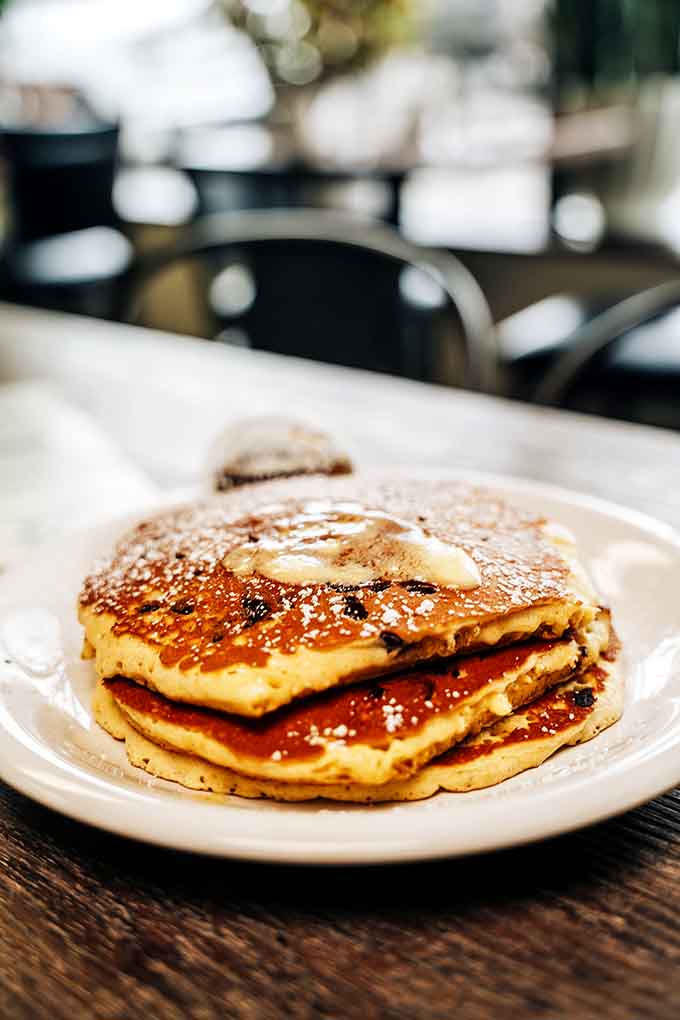 Pancakes stacked high with butter melting down like a delicious avalanche you actually want to be caught in.
