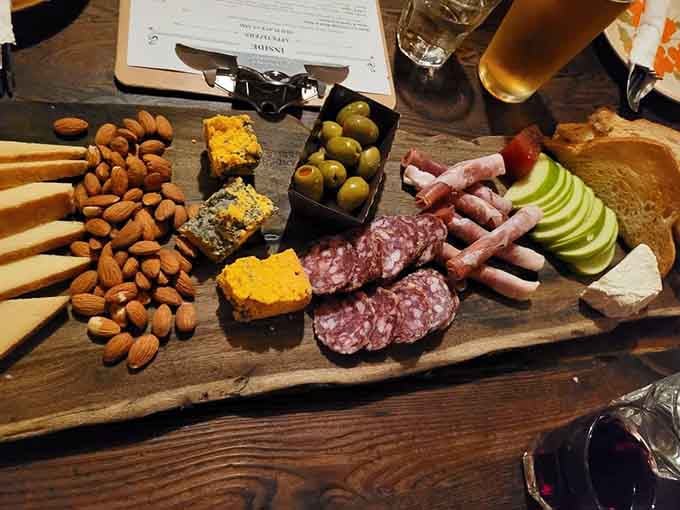 Cured meats, cheese, olives, and almonds arranged like edible art on rustic wood boards.