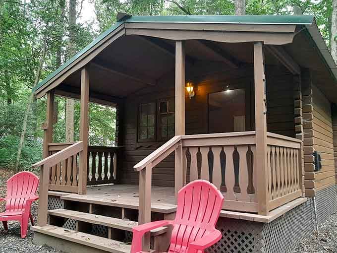 Rustic cabin living with pink Adirondack chairs, proving roughing it doesn't mean sacrificing a little personality and comfort.