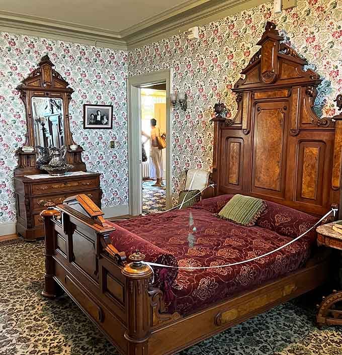 Victorian wallpaper and carved wood furniture create a bedroom where even ghosts would sleep comfortably.