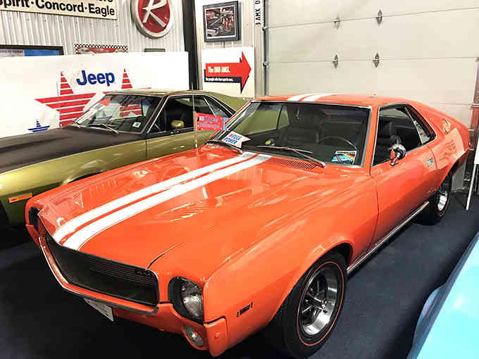 The AMX's orange paint and racing stripes scream "I was born to make Camaros nervous at stoplights."